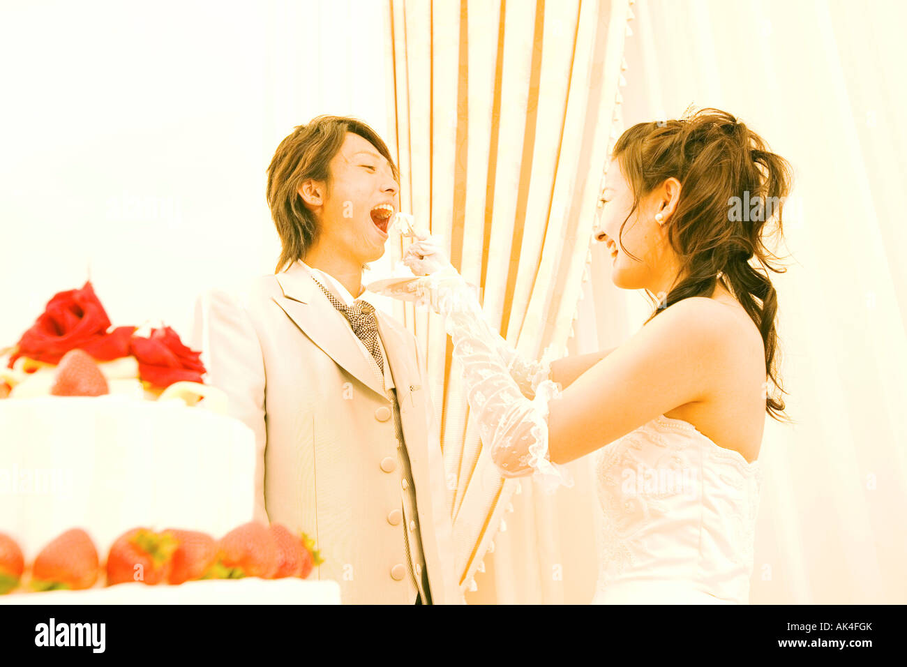 Bride feeding the bridegroom a piece of wedding cake Stock Photo - Alamy