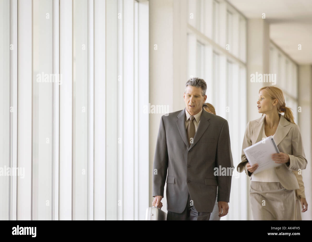 Group of business executives walking through corridor Stock Photo - Alamy