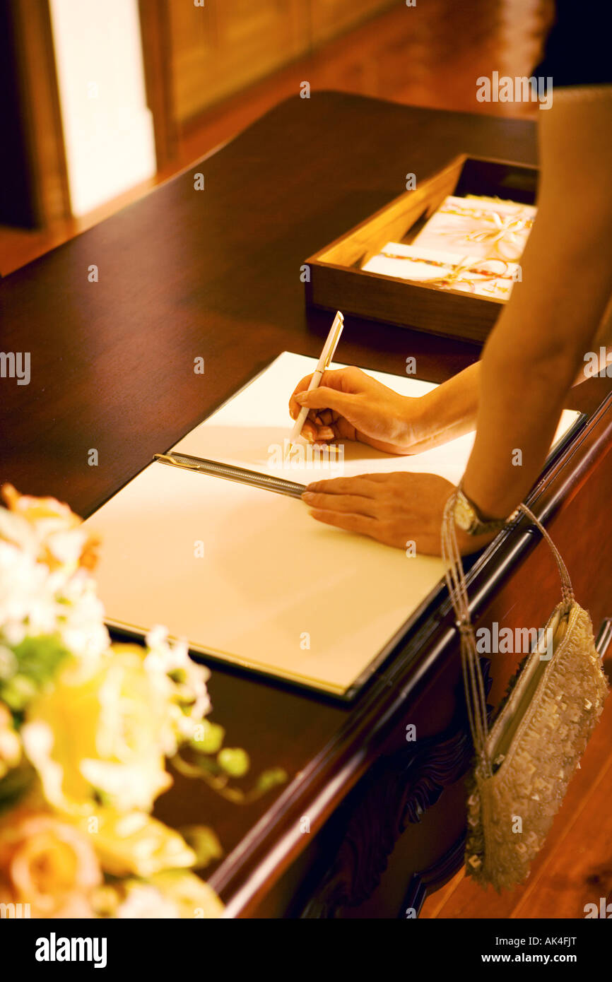 Close-up of woman signing on guest book Stock Photo - Alamy