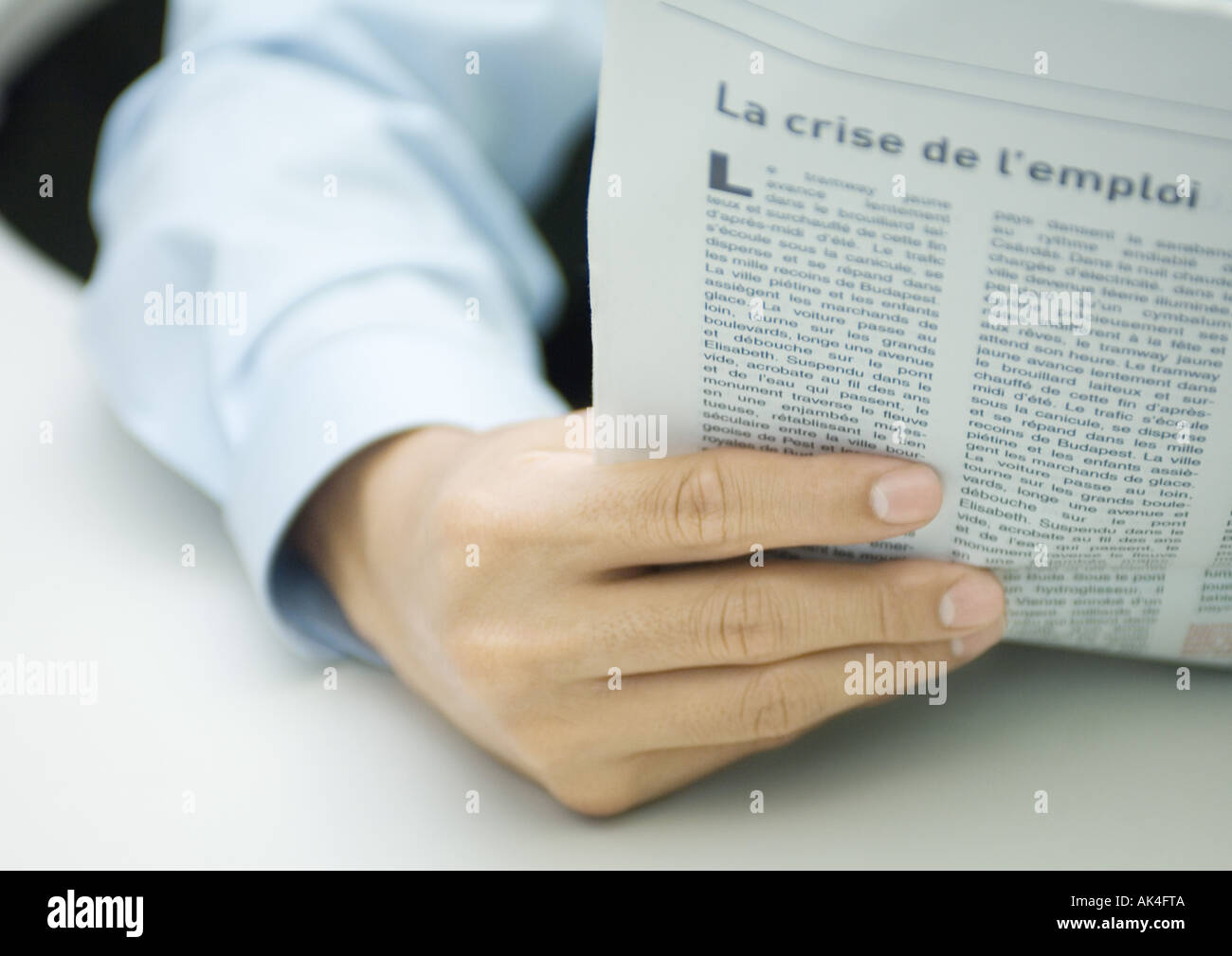 Man's hand holding newspaper Stock Photo - Alamy