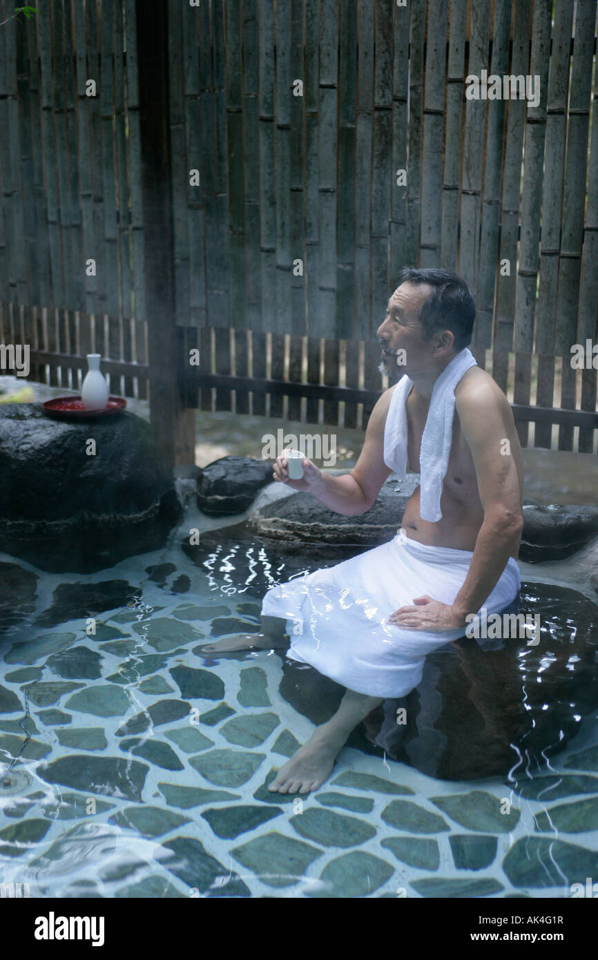 Man in hot spring, holding a cup Stock Photo - Alamy