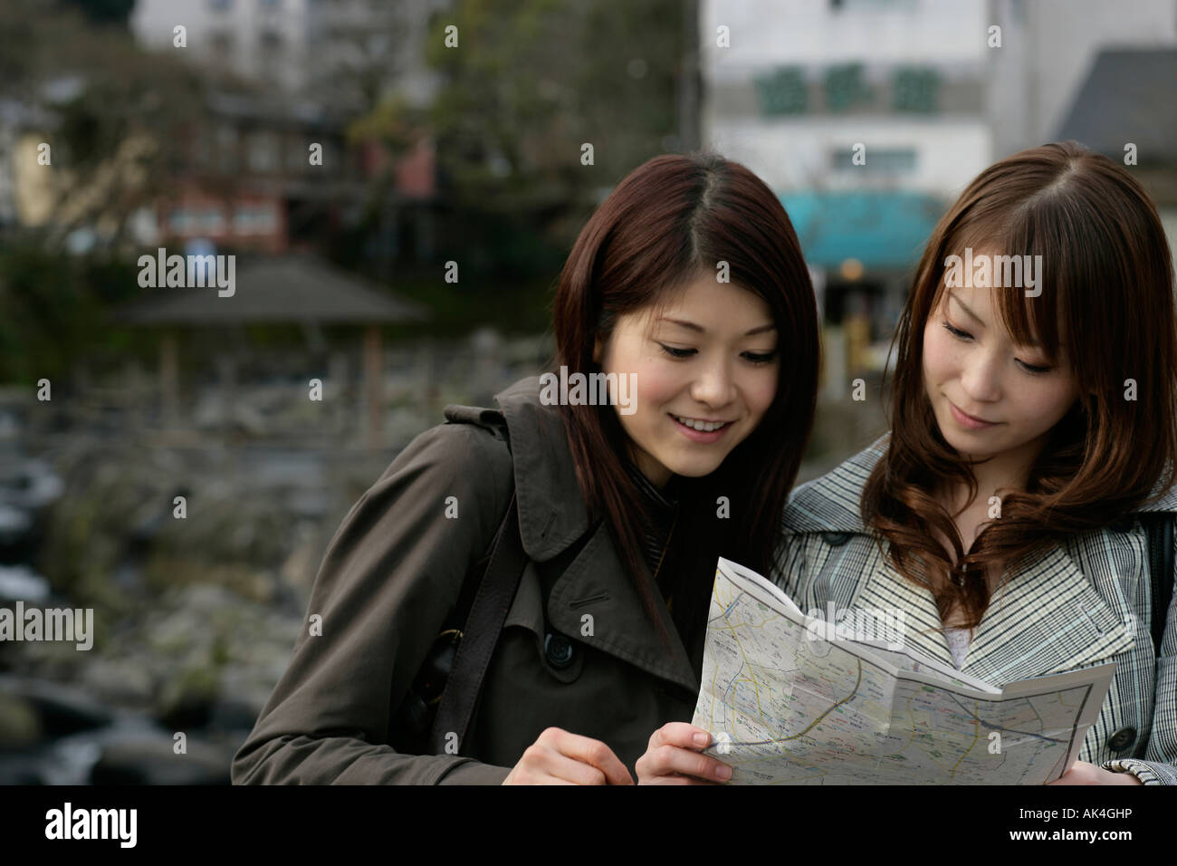 Two young women reading a map Stock Photo - Alamy