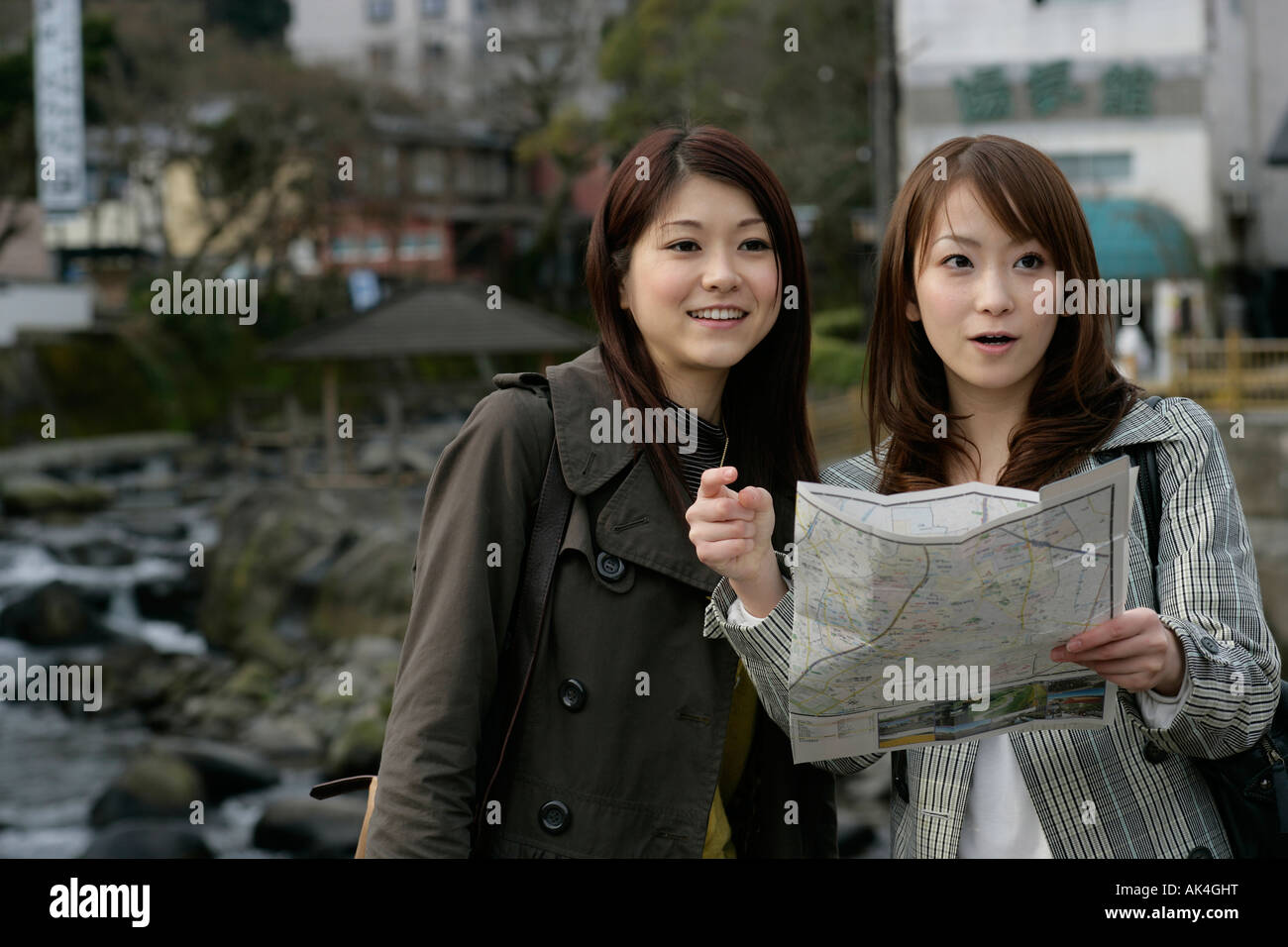 Two young women holding a map Stock Photo - Alamy