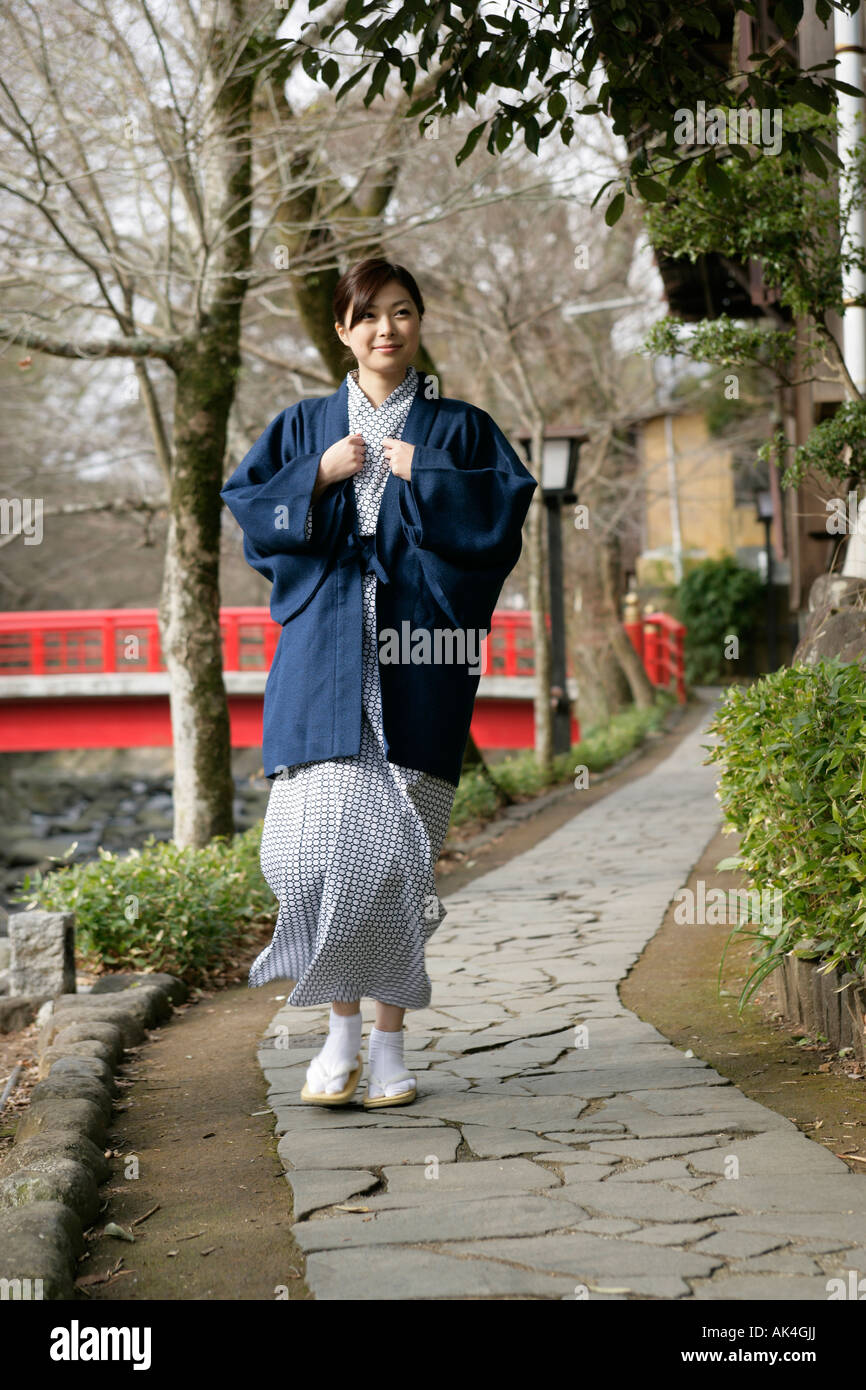 Young woman walking in the garden, wearing a blue robe Stock Photo - Alamy