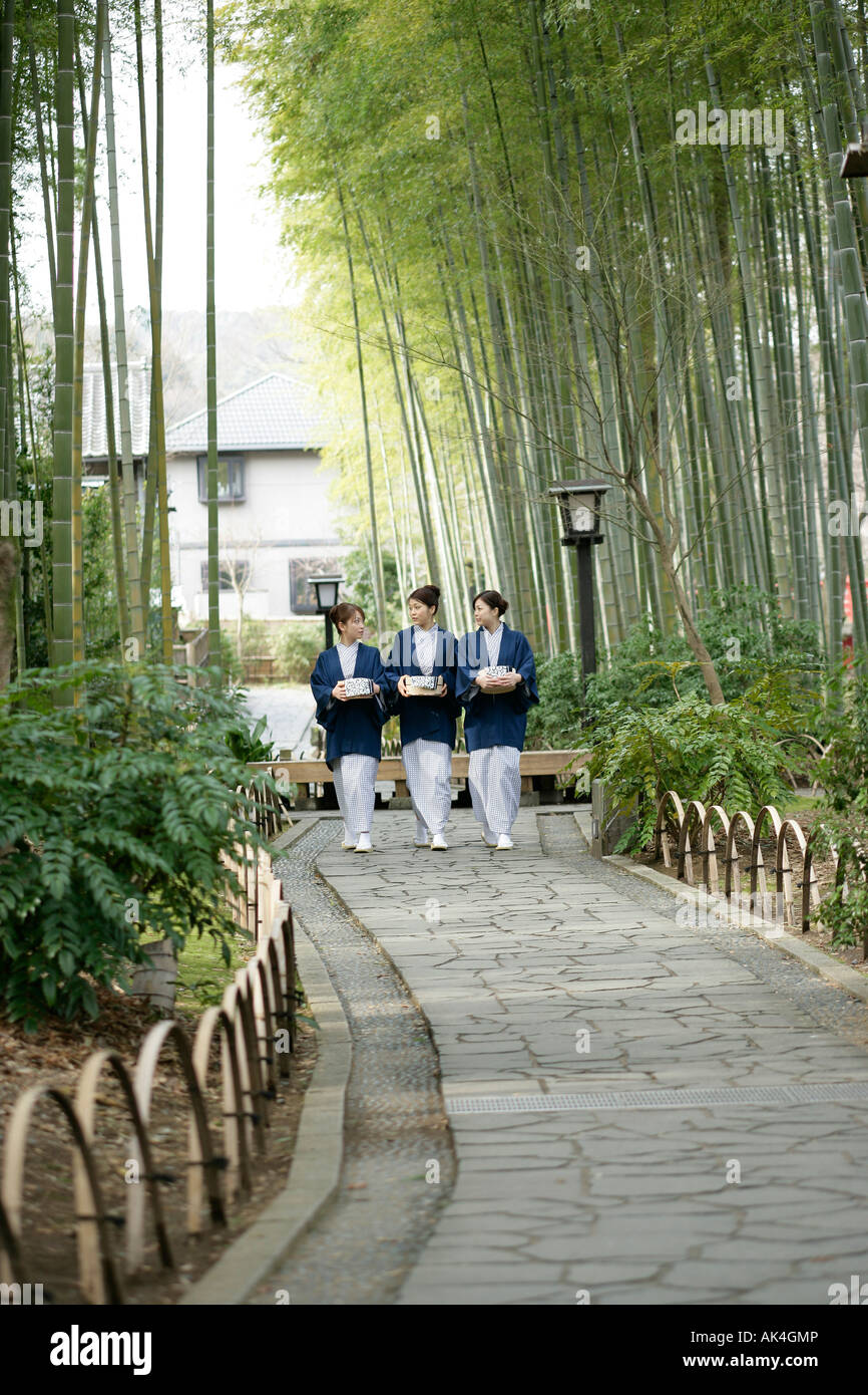 Three young women with buckets, walking Stock Photo - Alamy