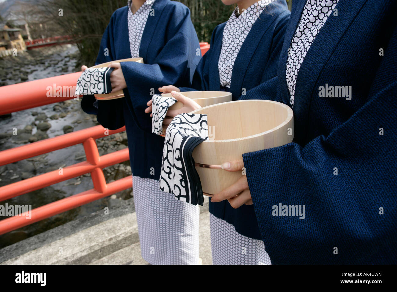 Three women with buckets, standing on bridge Stock Photo - Alamy