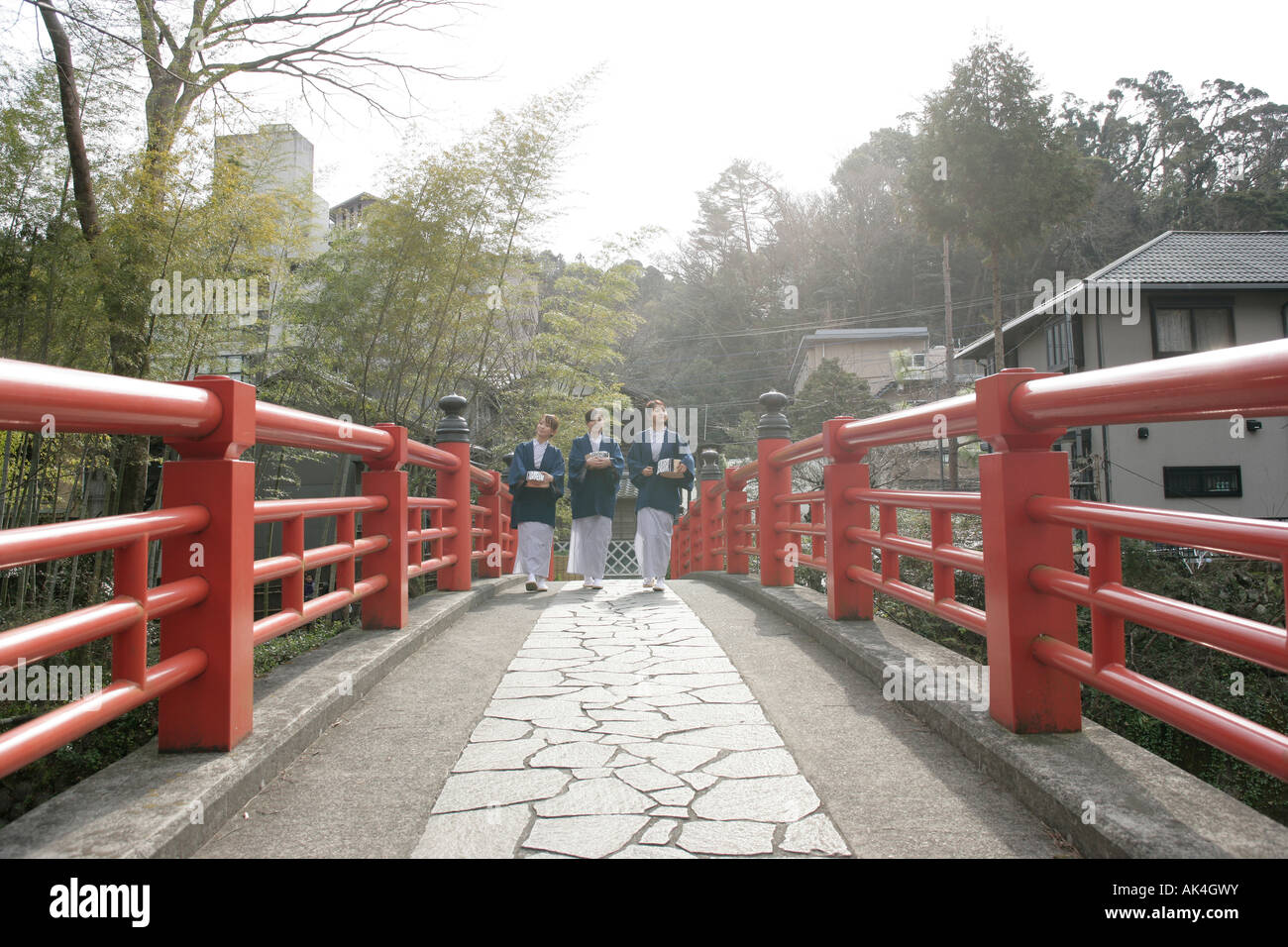 Three women with buckets, walking on bridge Stock Photo - Alamy