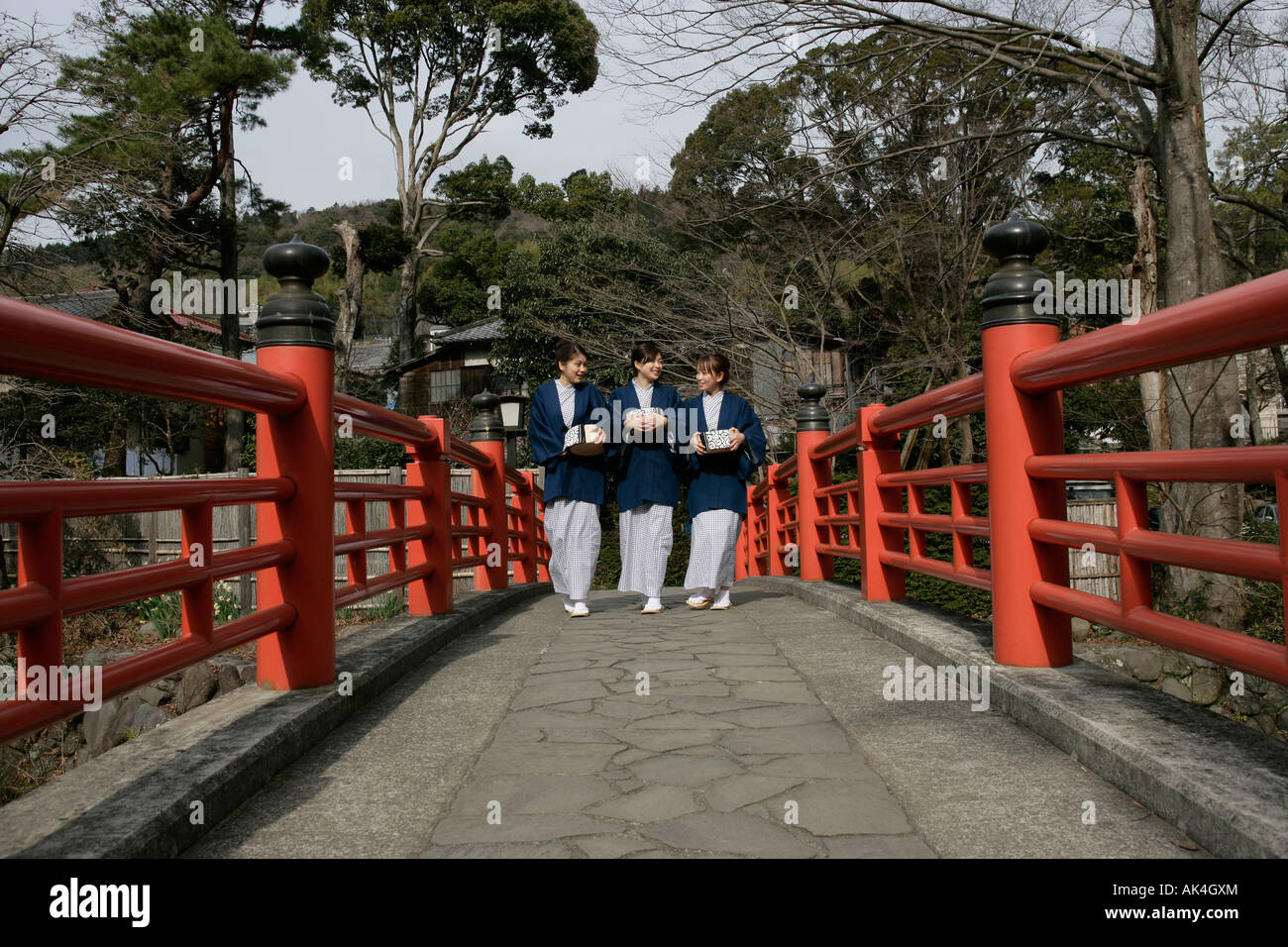 Three women with buckets, walking on bridge Stock Photo - Alamy