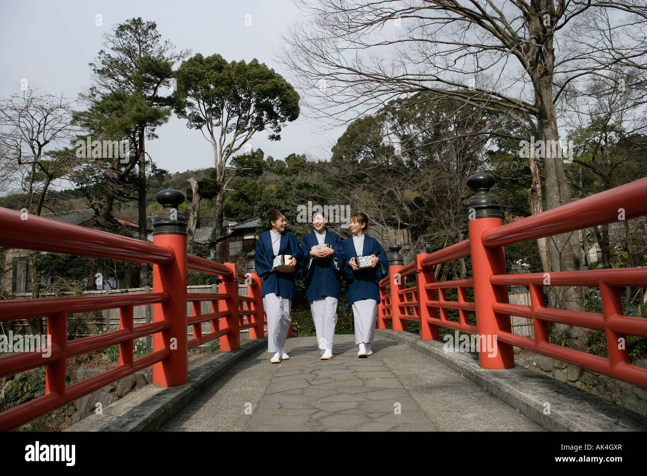 Three women with buckets, walking on bridge Stock Photo - Alamy
