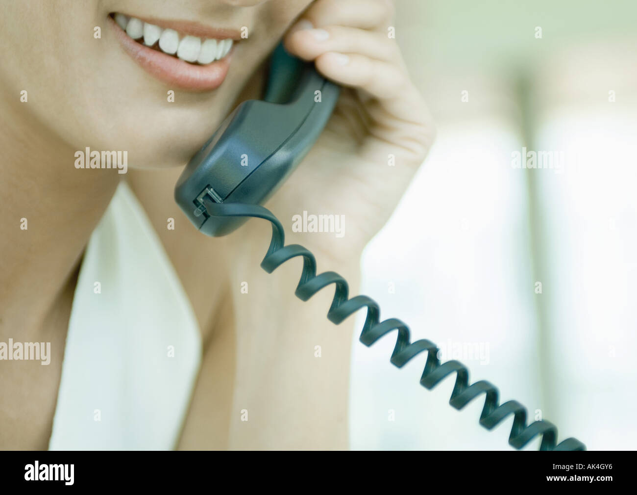 Woman using landline phone Stock Photo - Alamy