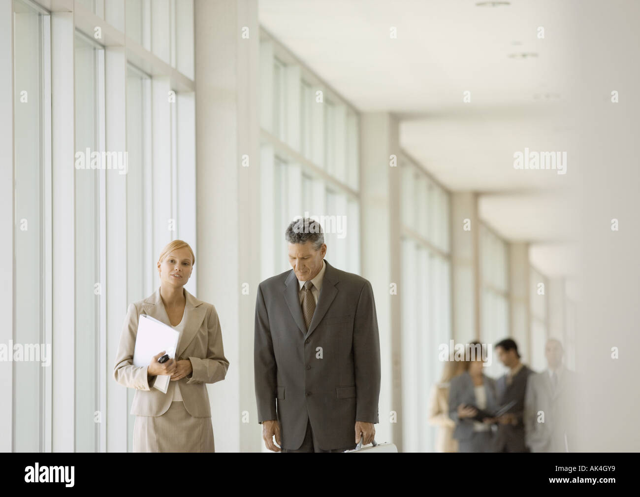 Executives walking through corridor of office building Stock Photo - Alamy