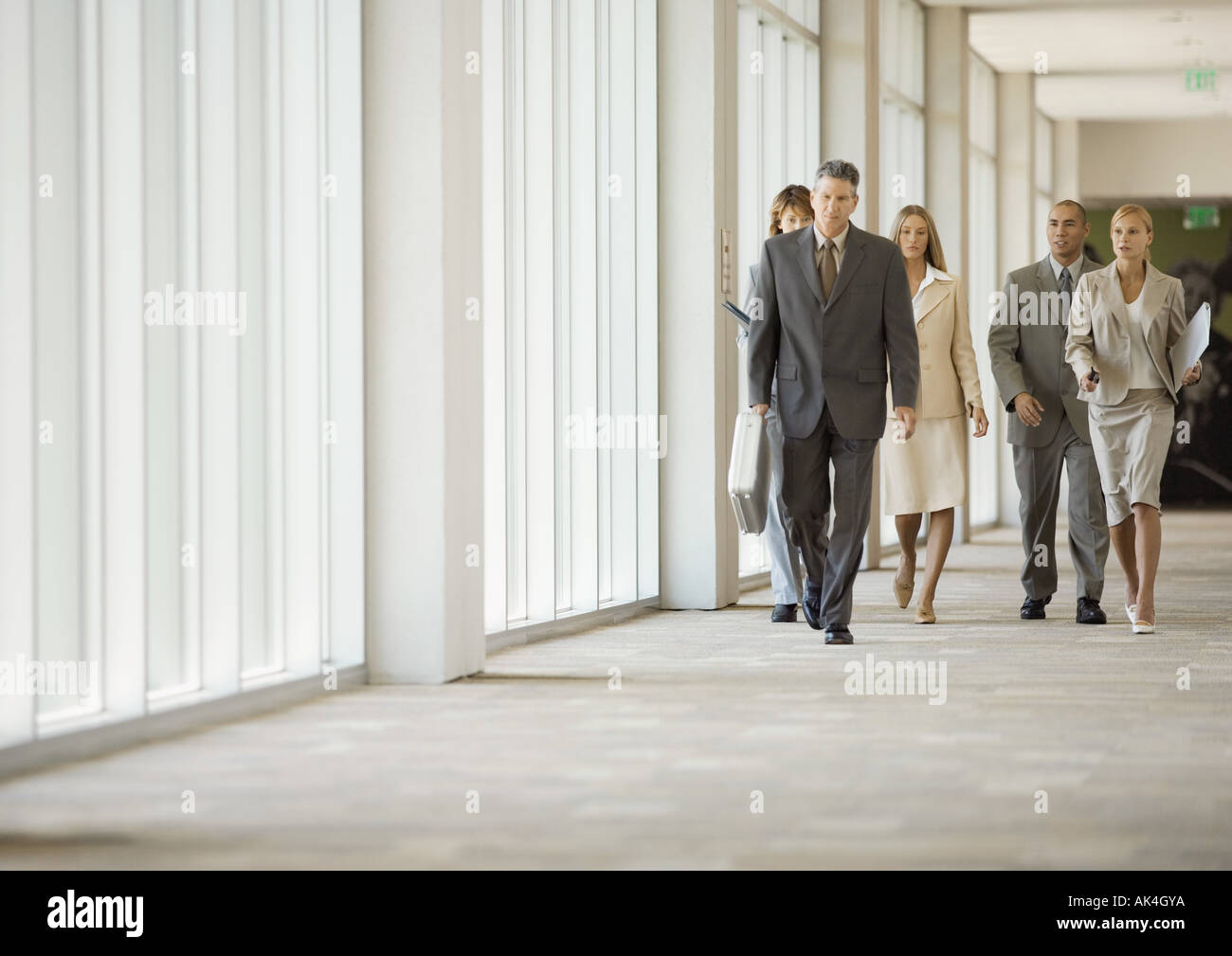 Executives walking through corridor of office building Stock Photo - Alamy