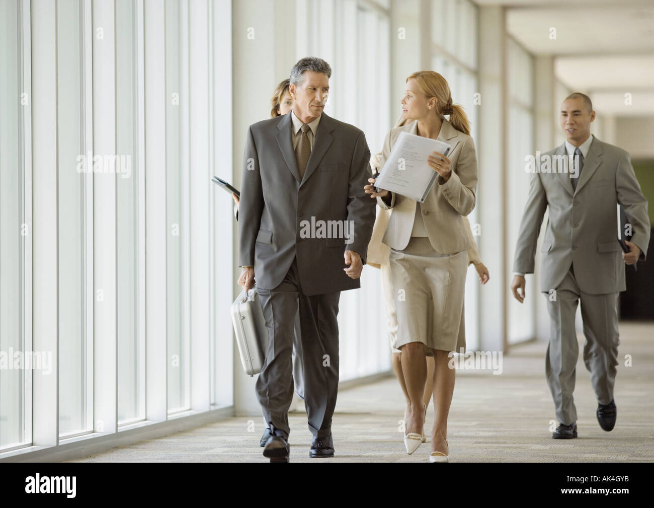 Executives walking through corridor of office building Stock Photo - Alamy