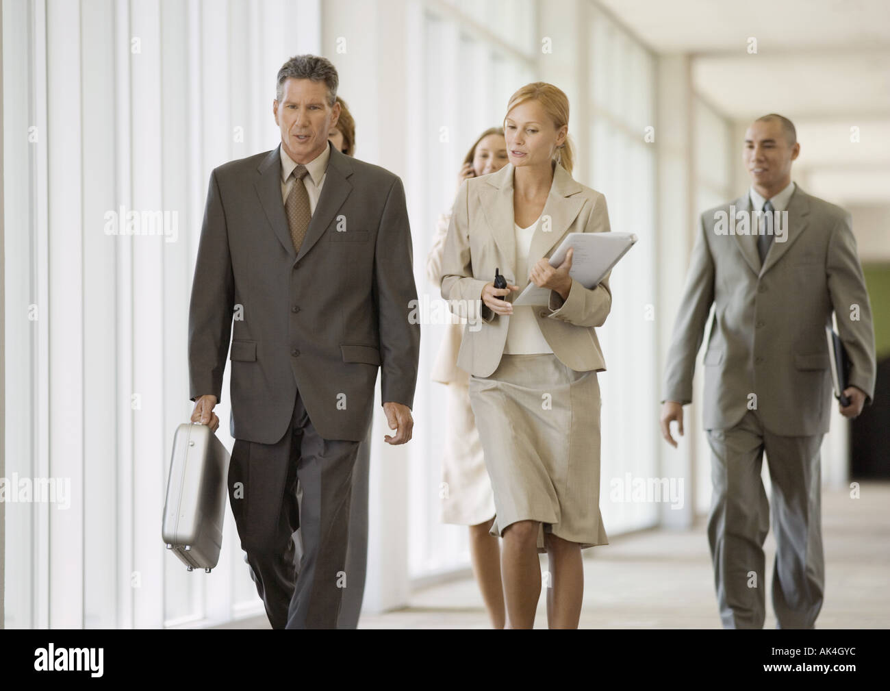 Executives walking through corridor of office building Stock Photo - Alamy