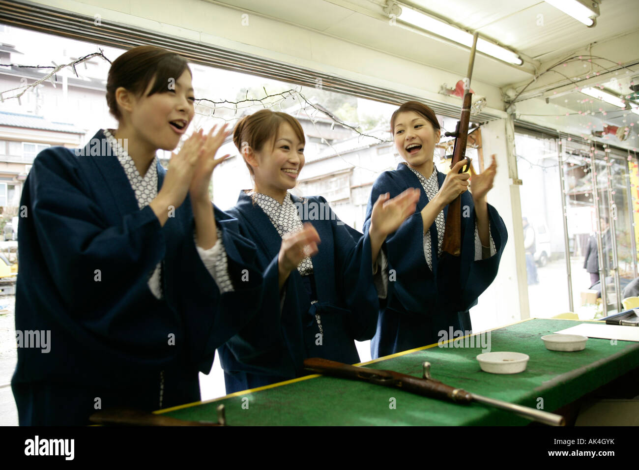 Three women in amusement arcade Stock Photo - Alamy