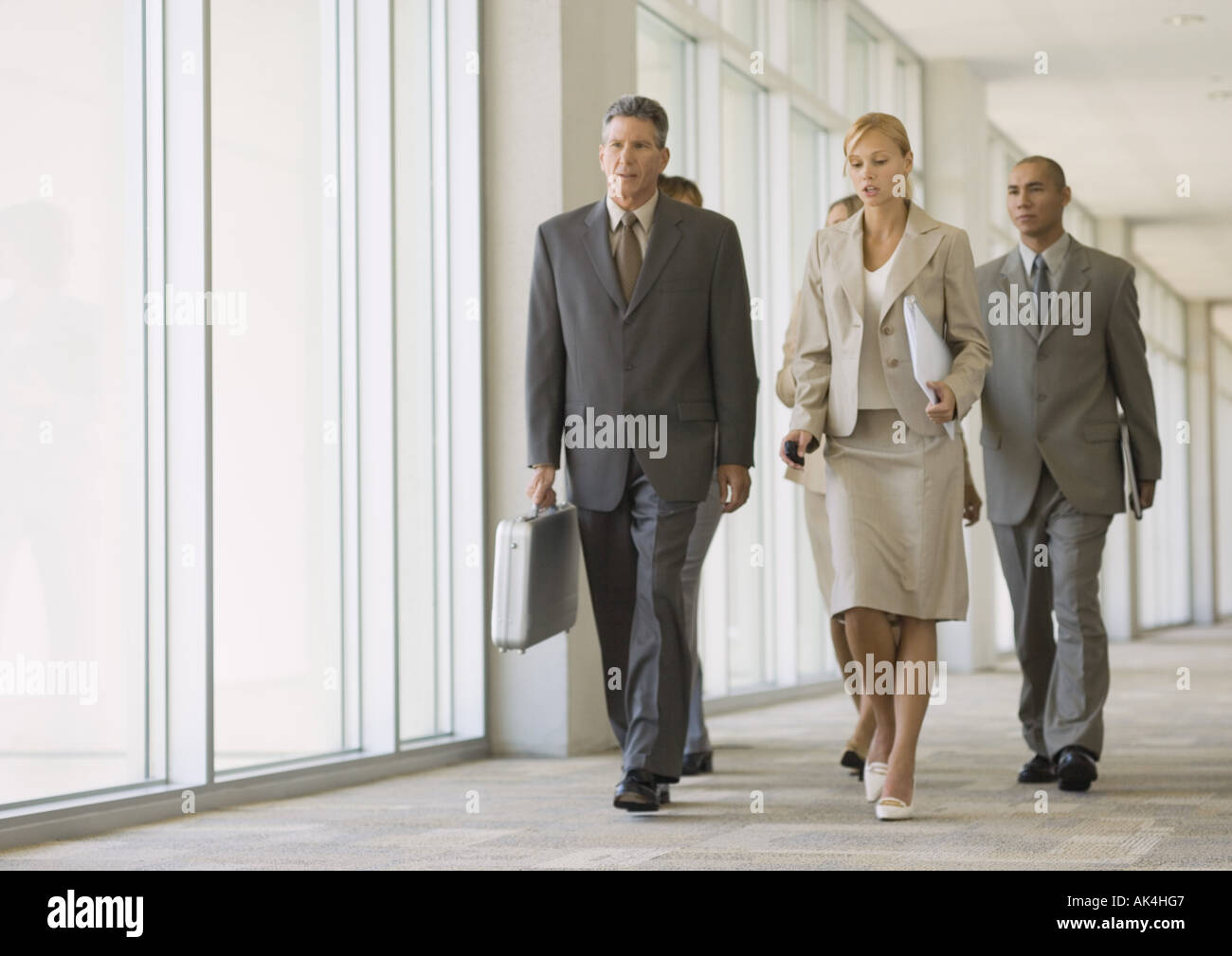 Executives walking through corridor of office building Stock Photo - Alamy