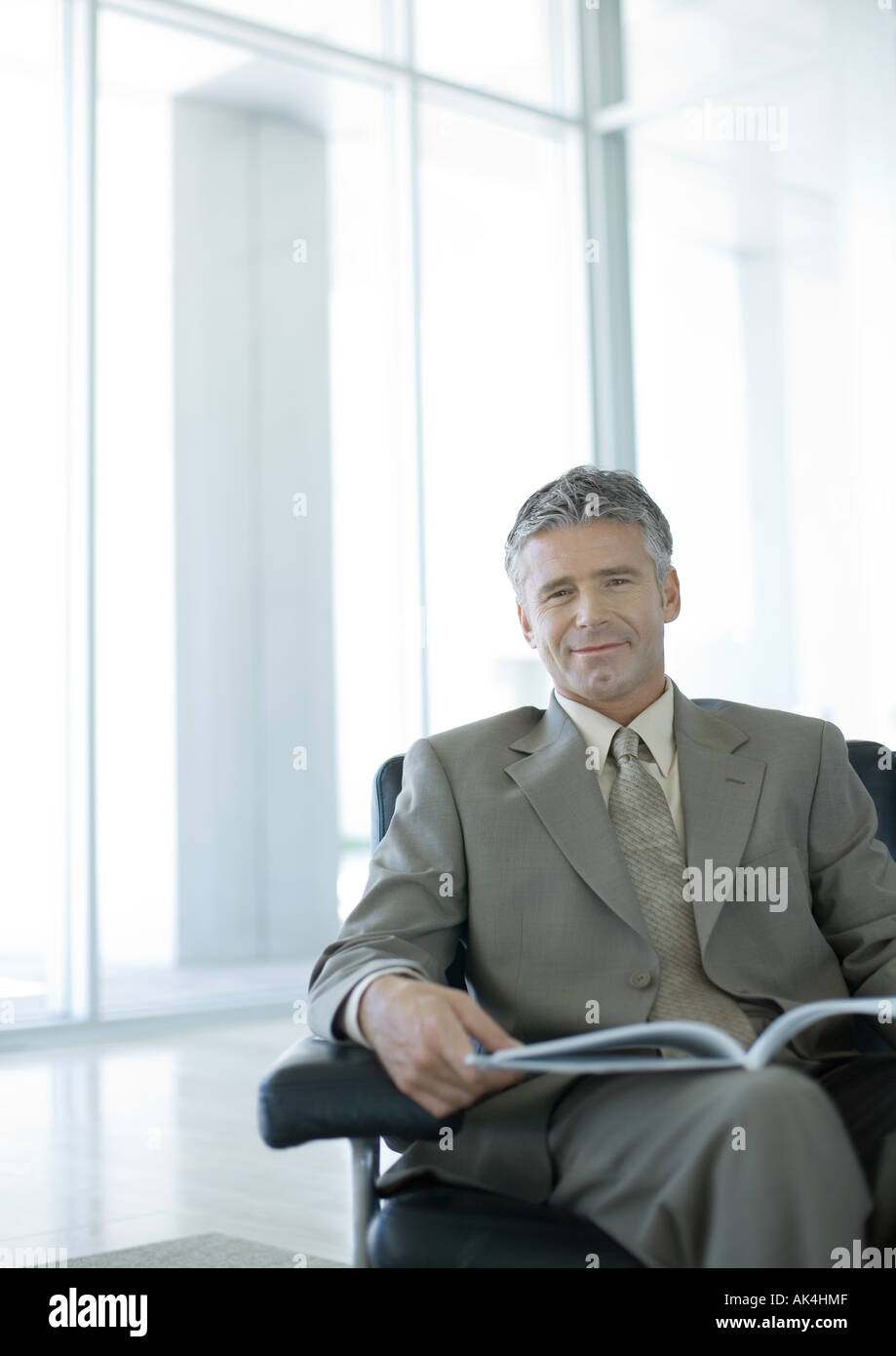 Businessman waiting in office lobby Stock Photo - Alamy