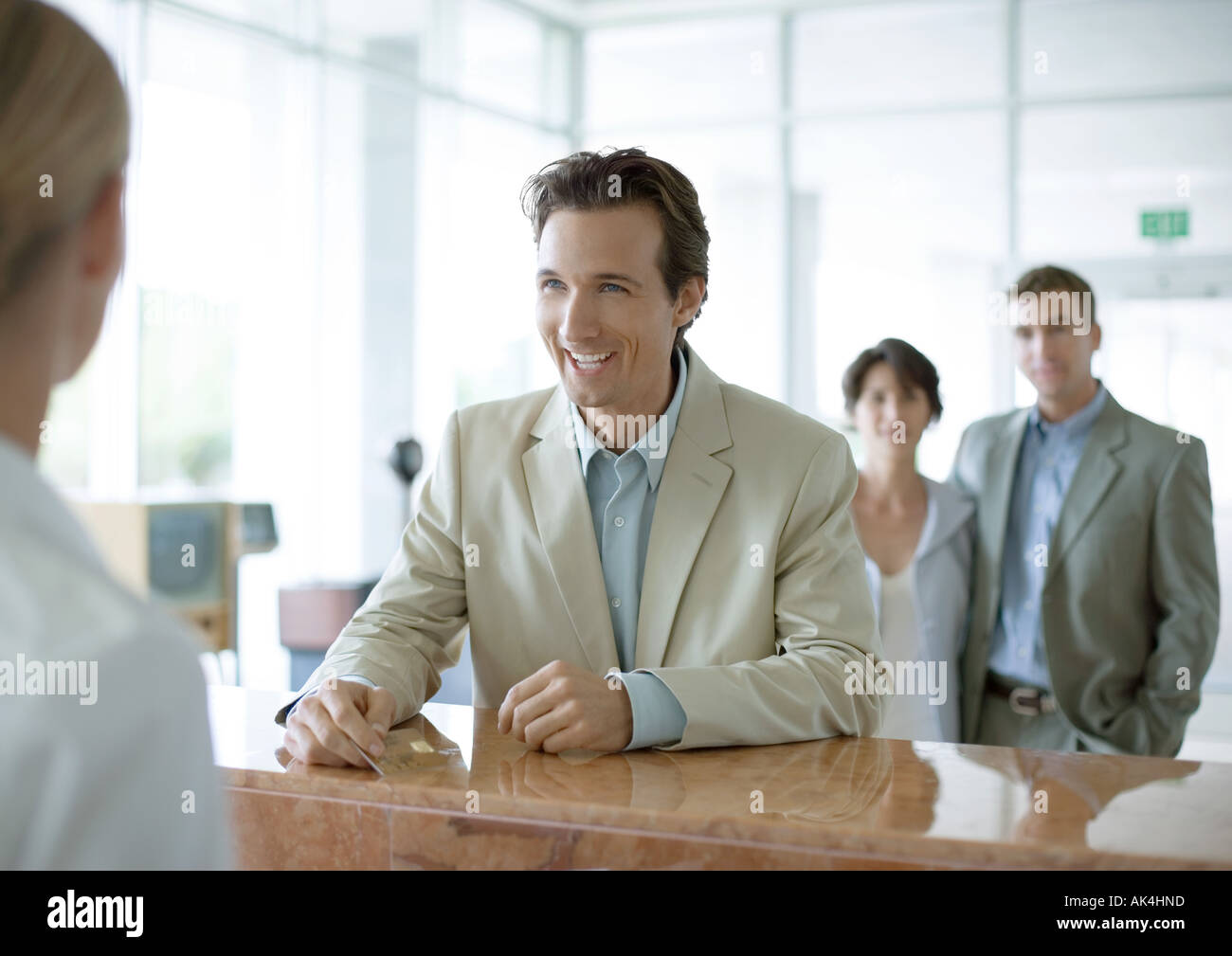 Man standing at reception desk Stock Photo - Alamy