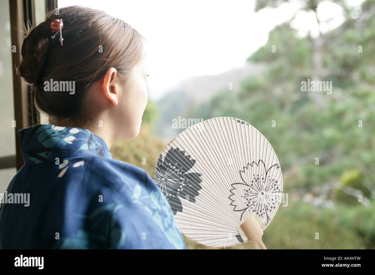 Woman in kimono and fan, staring into the garden Stock Photo - Alamy