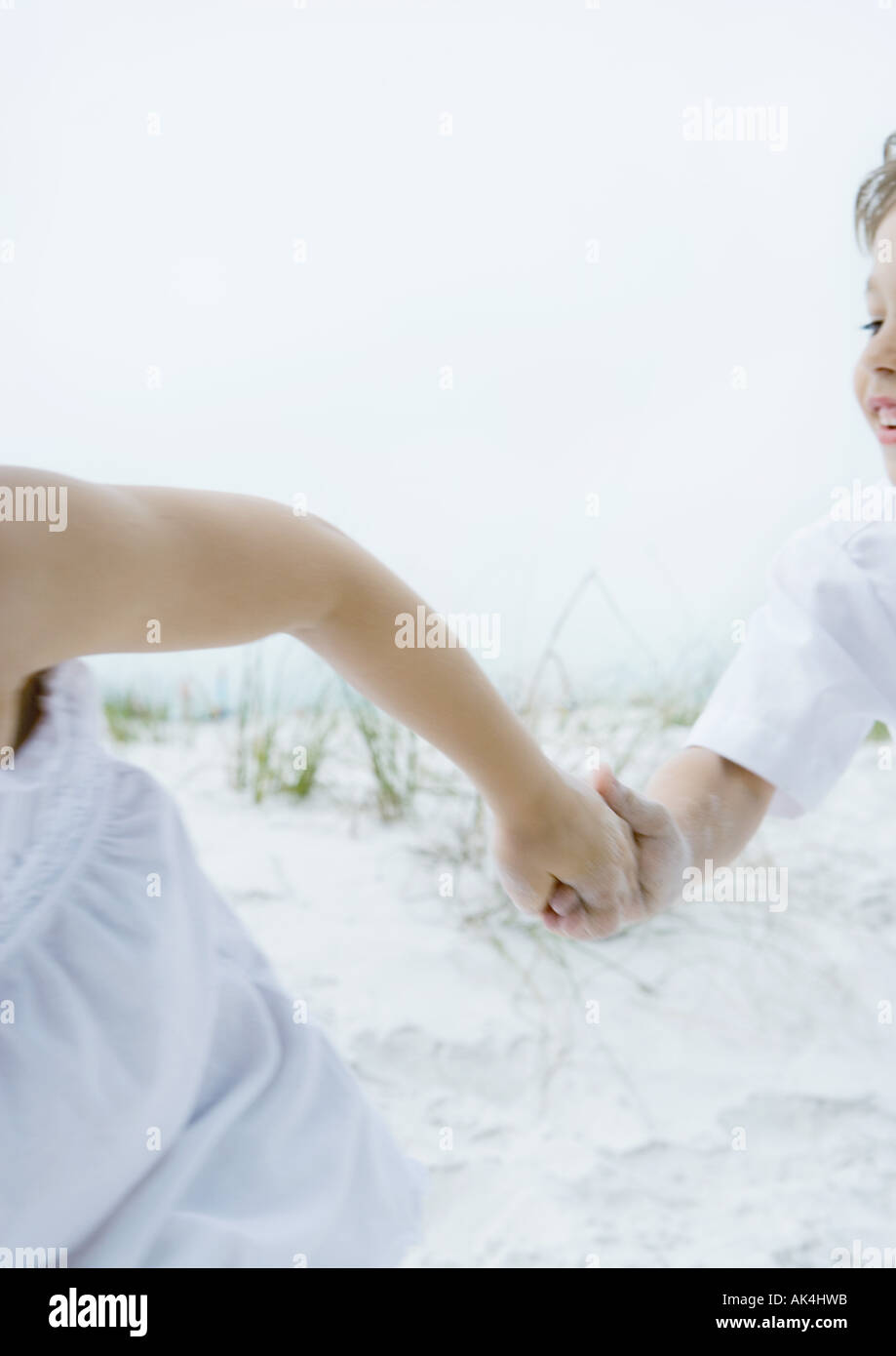 Two children holding hands and running, close-up of arms Stock Photo ...