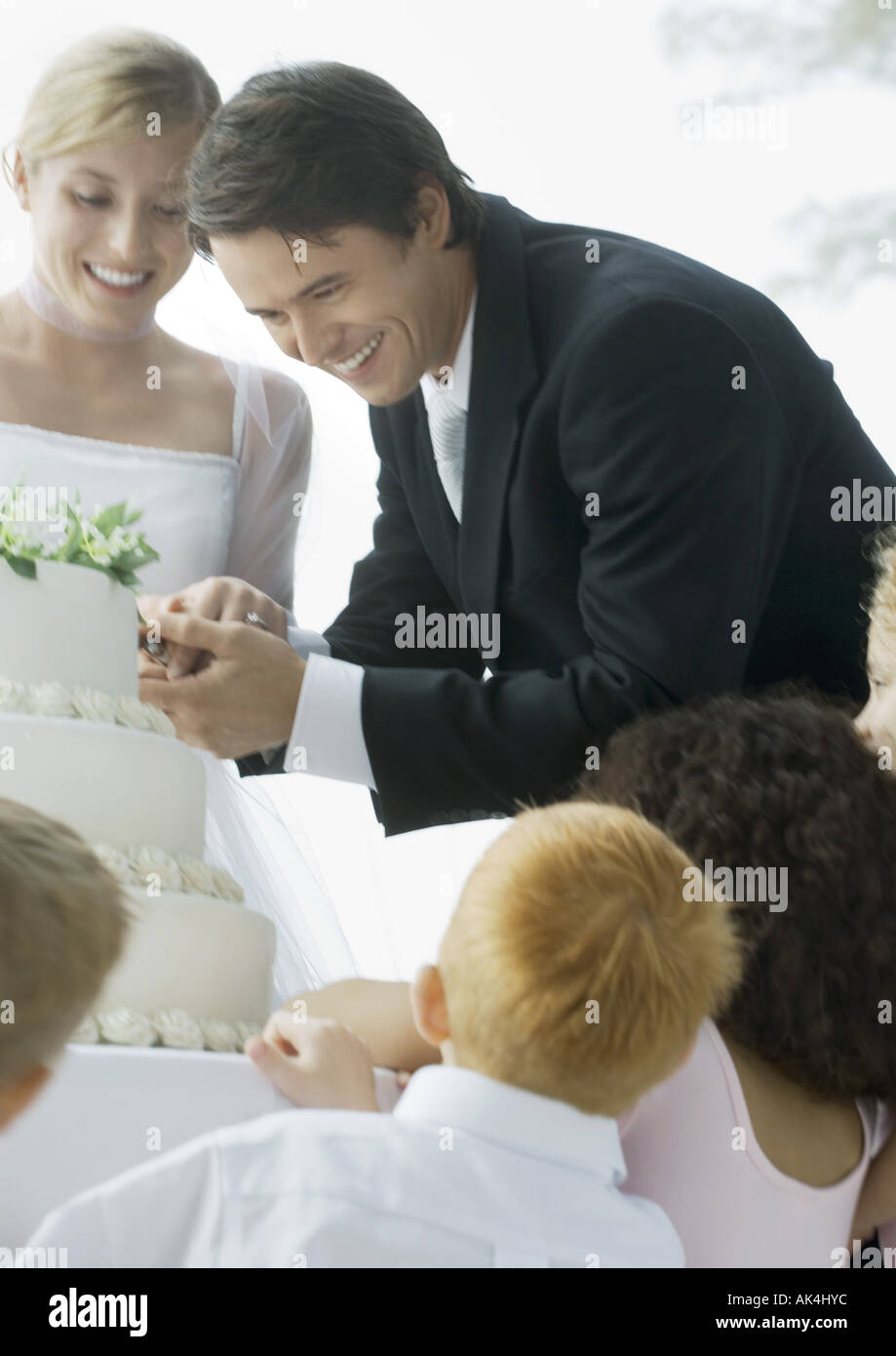 Groom cutting wedding cake Stock Photo - Alamy