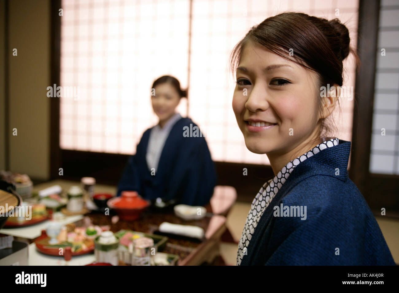 Two women by dinner table Stock Photo - Alamy