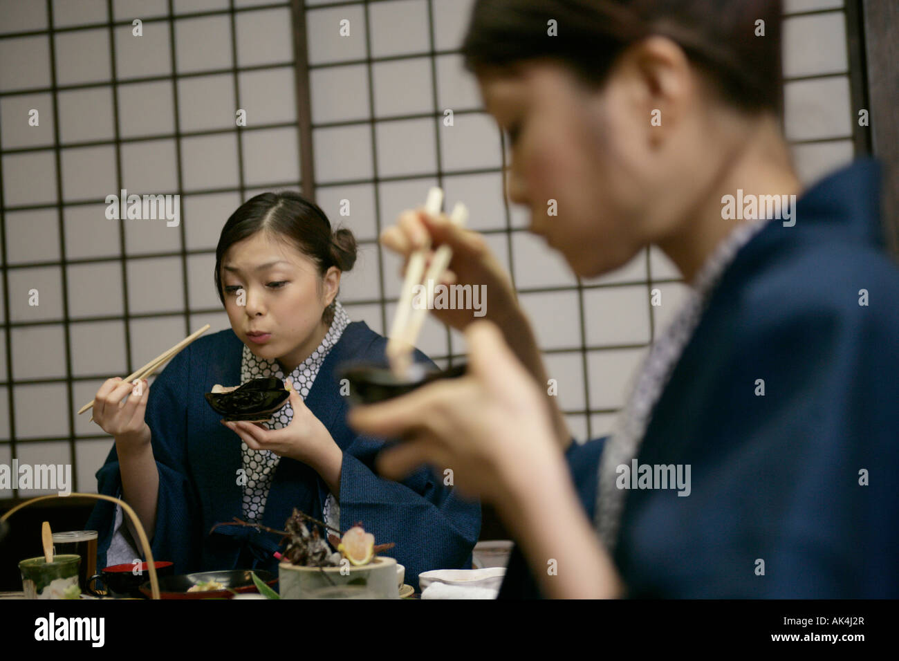 Two women eating with chopsticks Stock Photo - Alamy