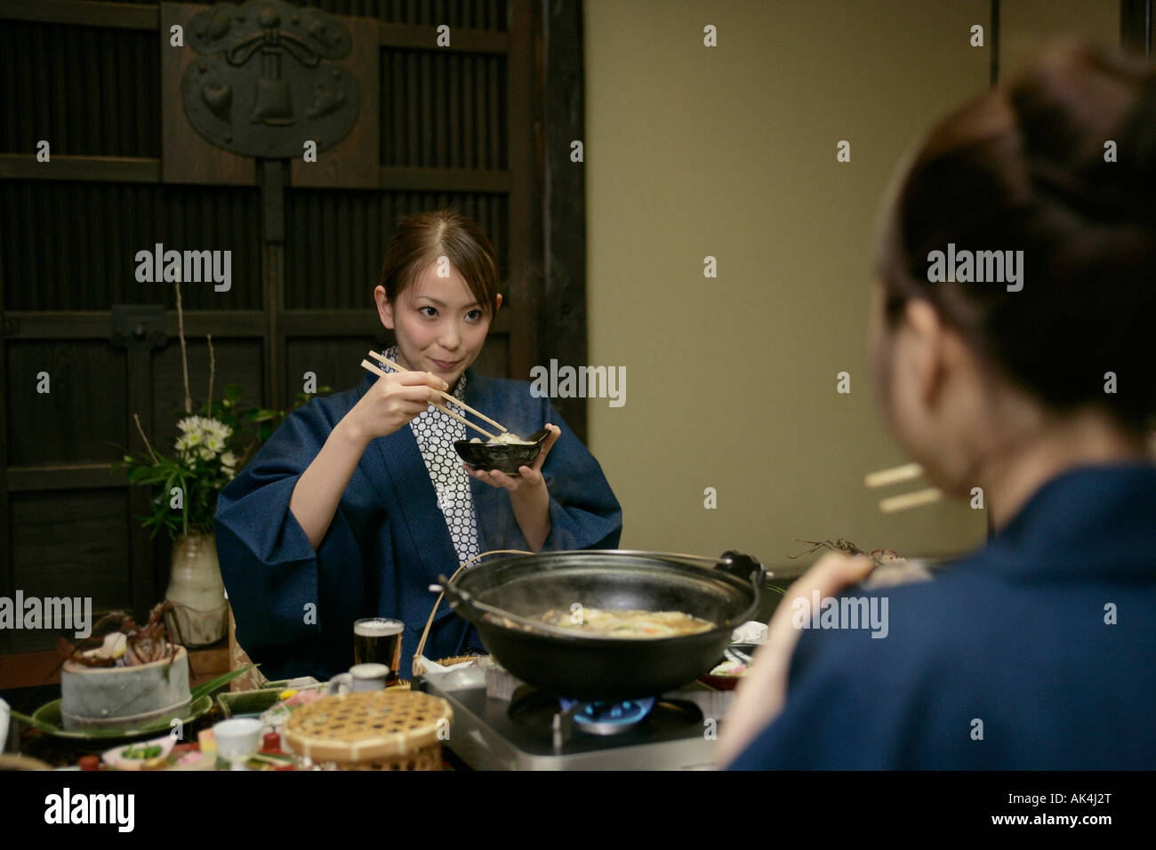 Two women eating with chopsticks Stock Photo - Alamy