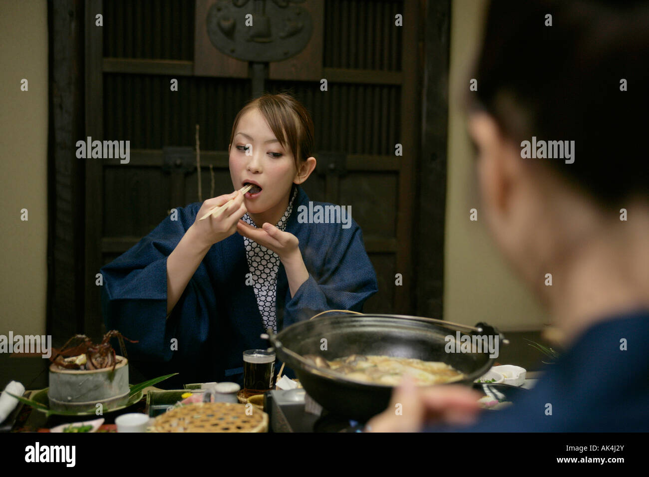 Two women eating with chopsticks Stock Photo - Alamy