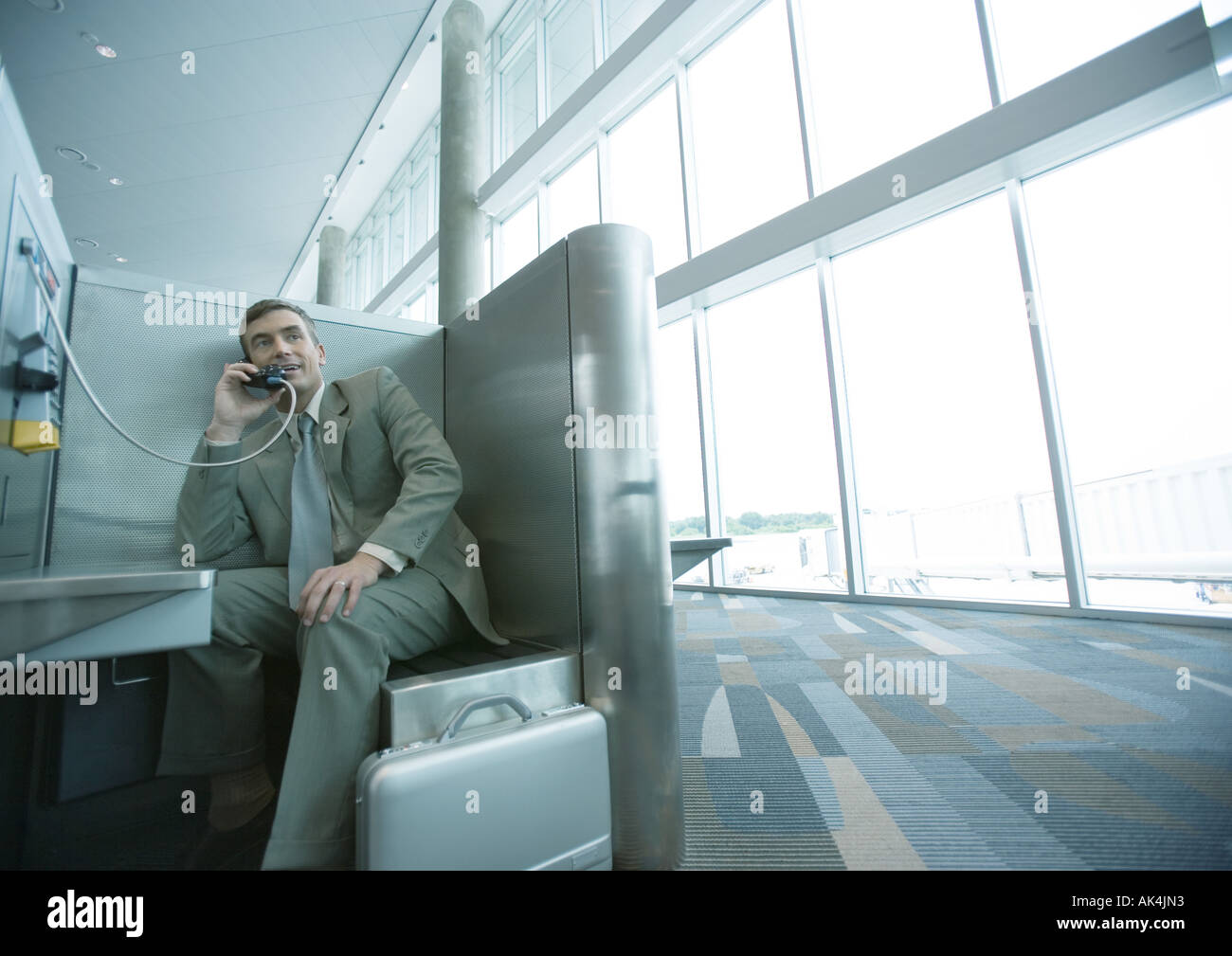 Businessman using pay phone in airport Stock Photo - Alamy