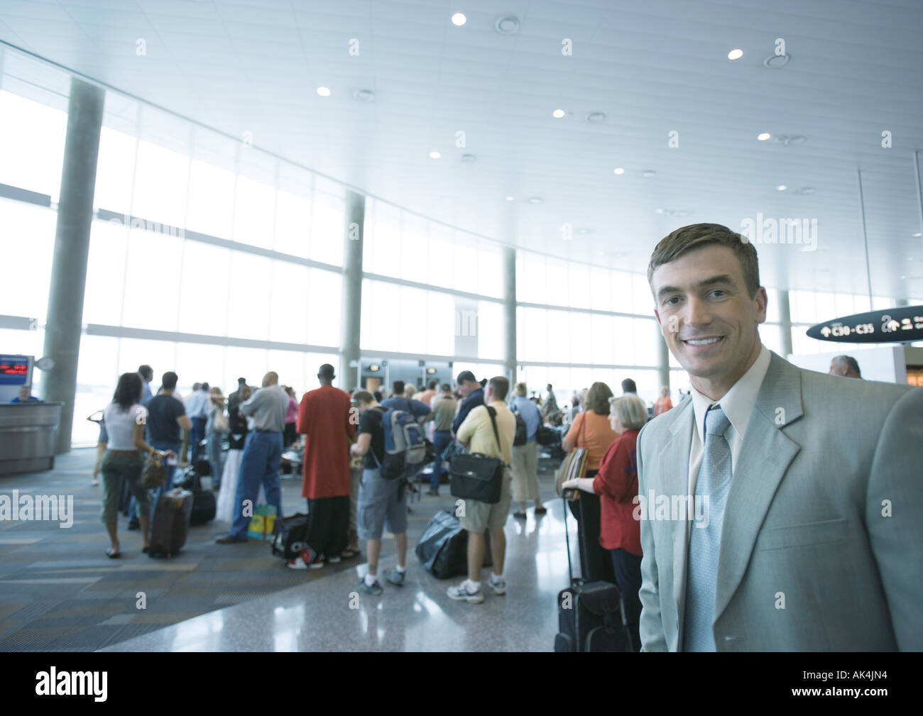 Businessman standing in airport boarding area Stock Photo - Alamy