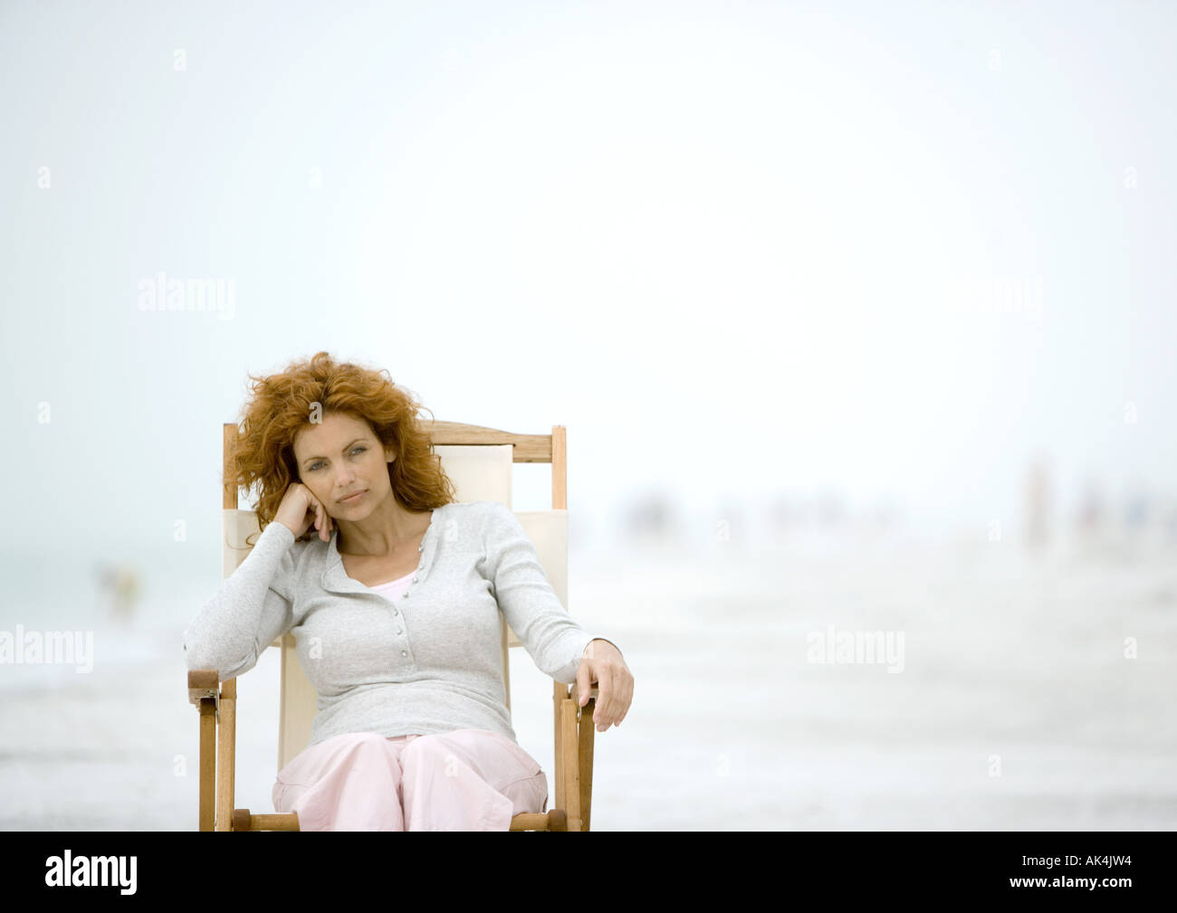 Woman sitting in beach chair Stock Photo - Alamy