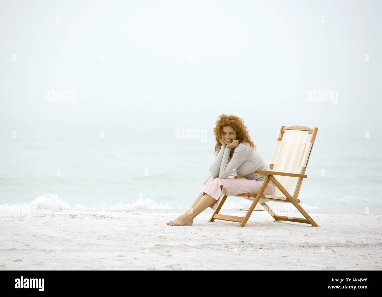 Woman sitting in beach chair Stock Photo - Alamy
