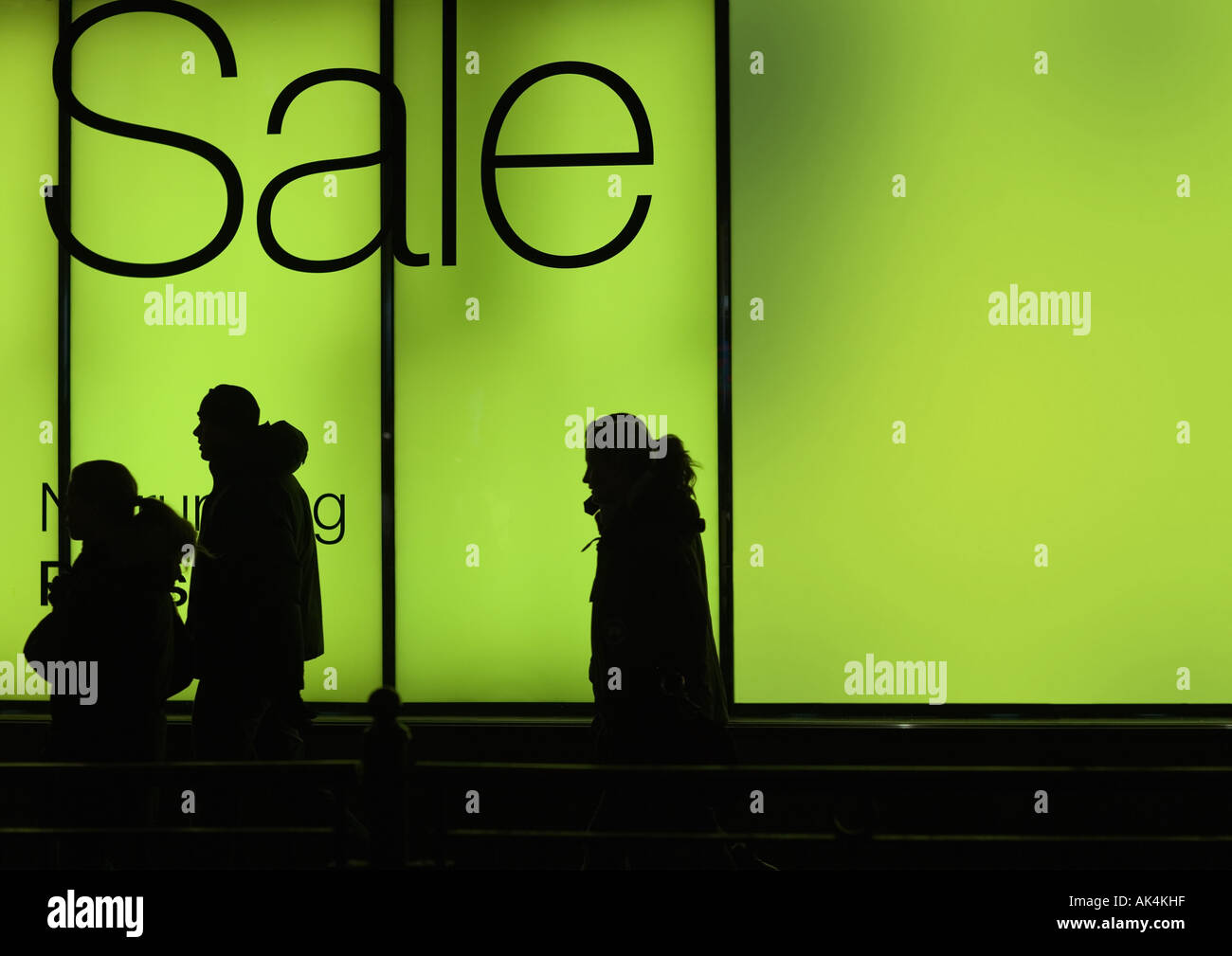 Sale sign in shop window and silhouettes of passers-by Stock Photo - Alamy