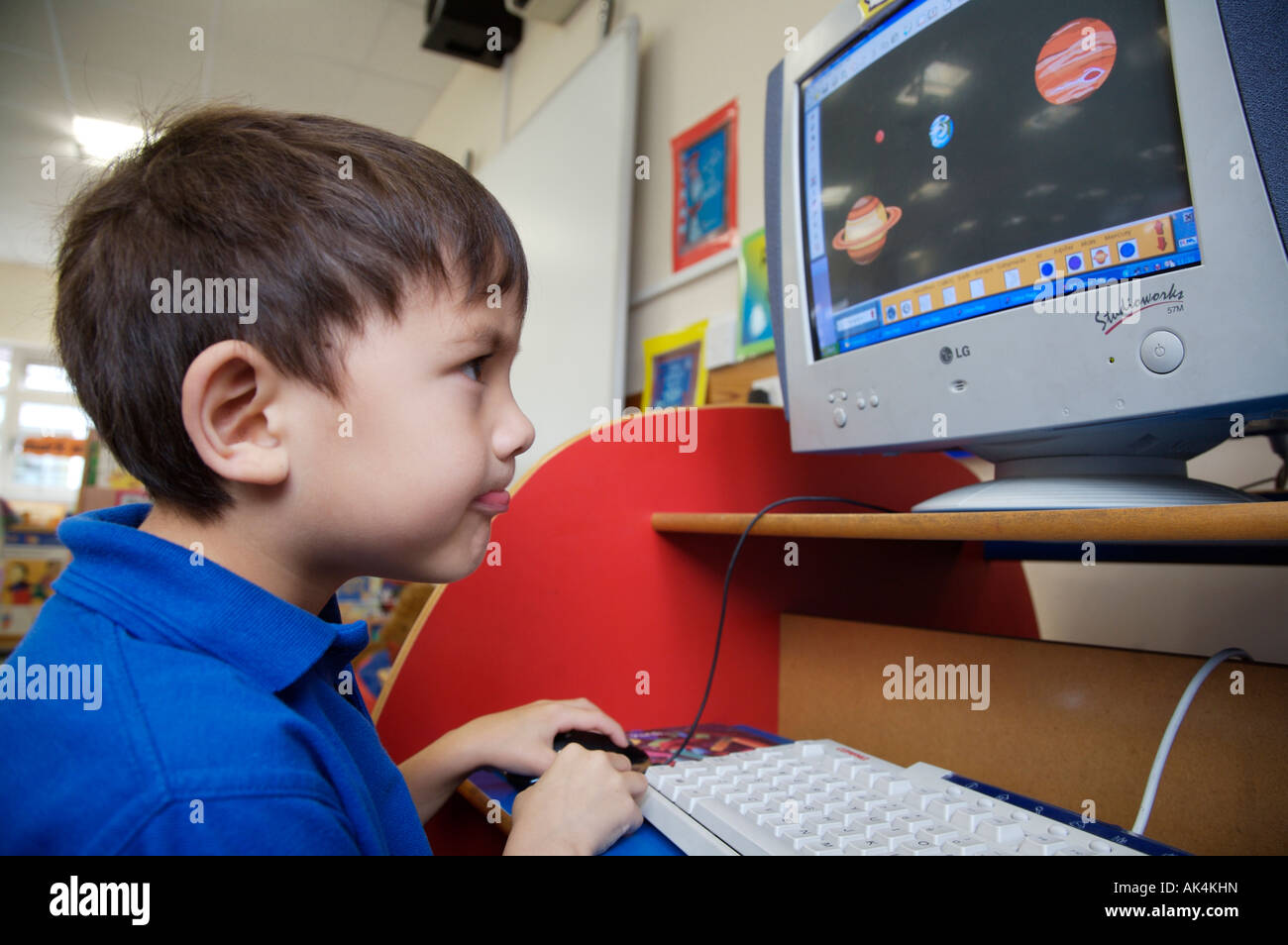 A young child using a school computer in his classroom Stock Photo - Alamy