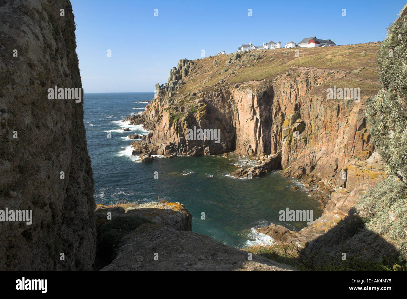Sea cliff and visitors centre at Land's End through gap in rocks ...