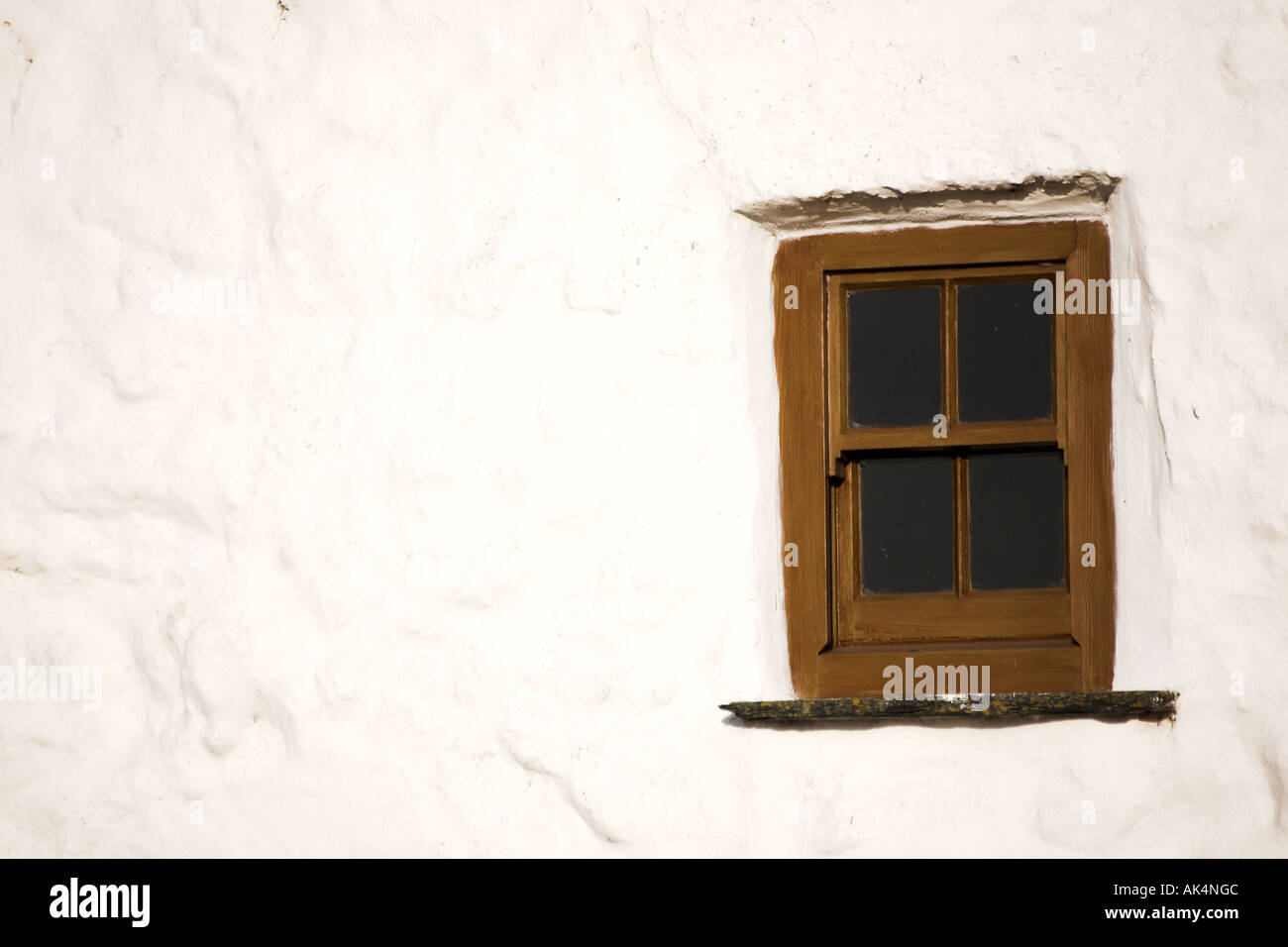 Small brown window with black ledge set in right hand side of white ...