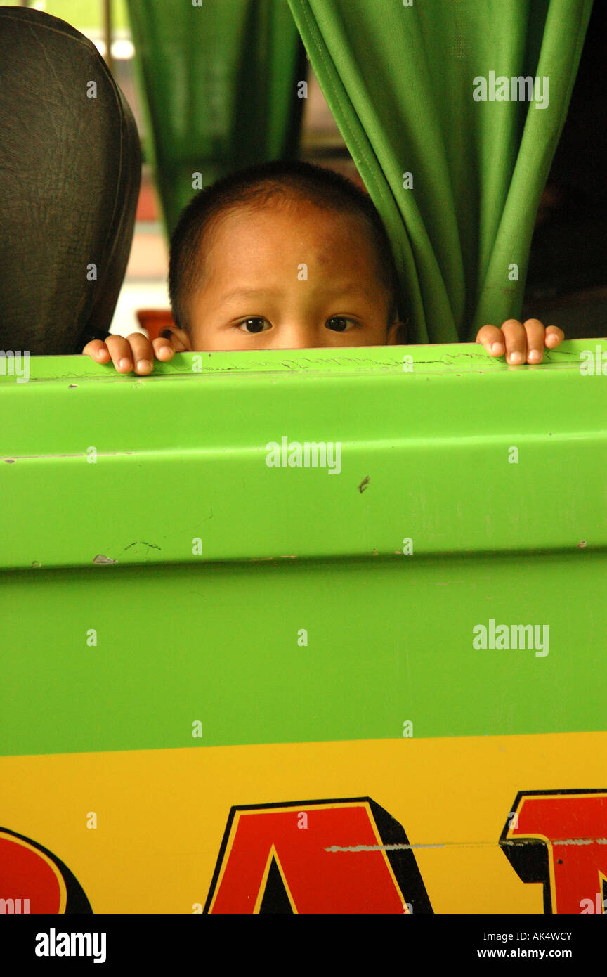 Shy Child peering out of a bus window in the Philippines Stock Photo ...