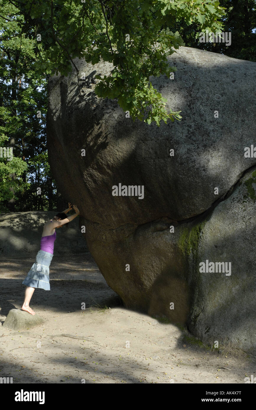 Woman pushing a large rock Stock Photo - Alamy