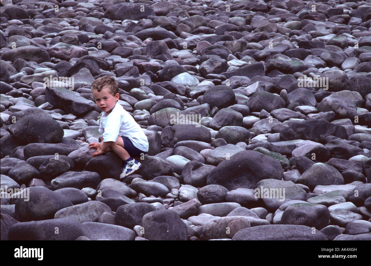 Boy and stones Stock Photo - Alamy