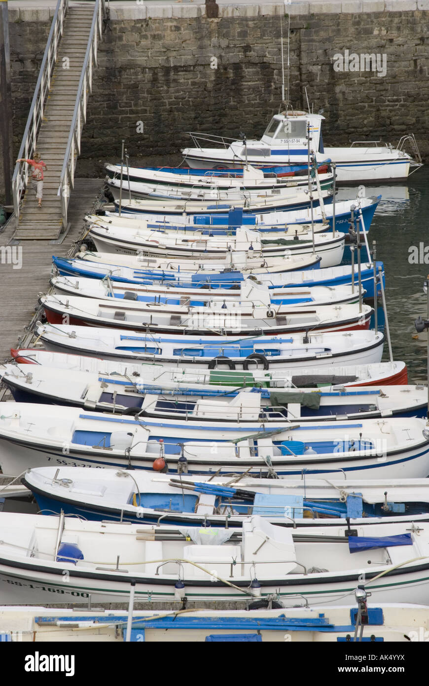 Fishing boats lined up along a jetty in the harbour of Getaria on Spain ...