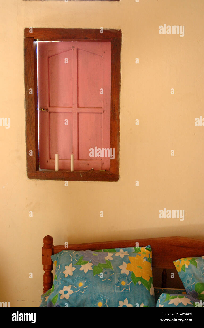 Pink shutters and blue bed linen in a budget hotel in Indonesia Stock ...