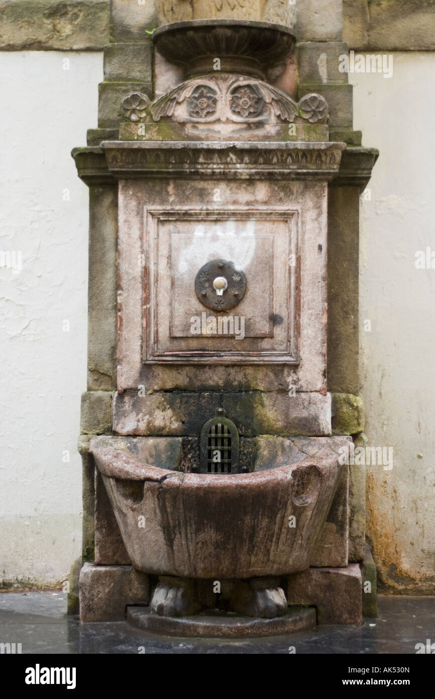 A stained water fountain in a back alley in San Sebastian's historic ...
