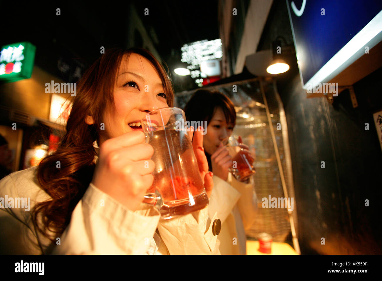 Two women having beers at night Stock Photo - Alamy
