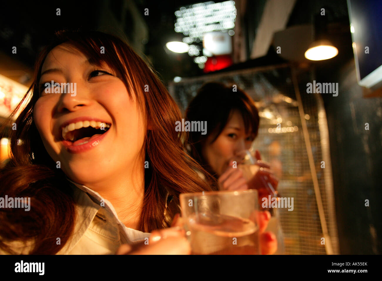 Two women having beers at night Stock Photo - Alamy