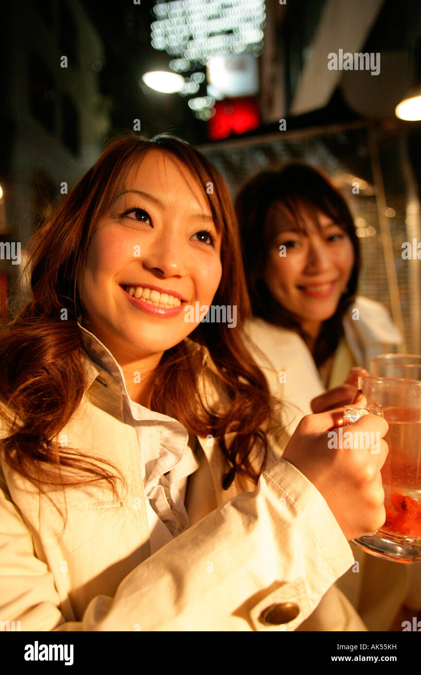 Two women having beers at night Stock Photo - Alamy