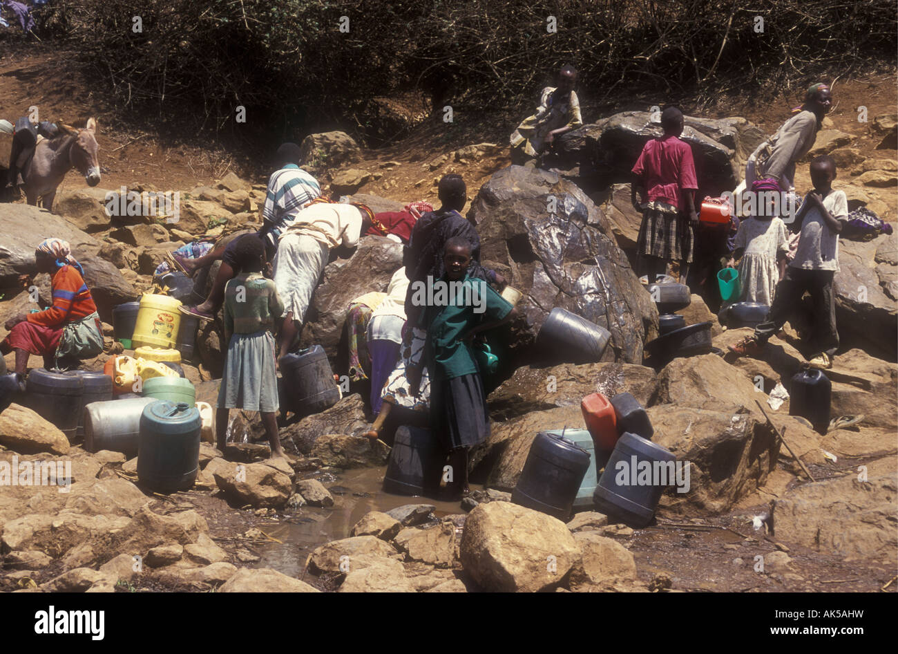 Crowd of Meru people crowd around a tiny spring to collect water Meru ...