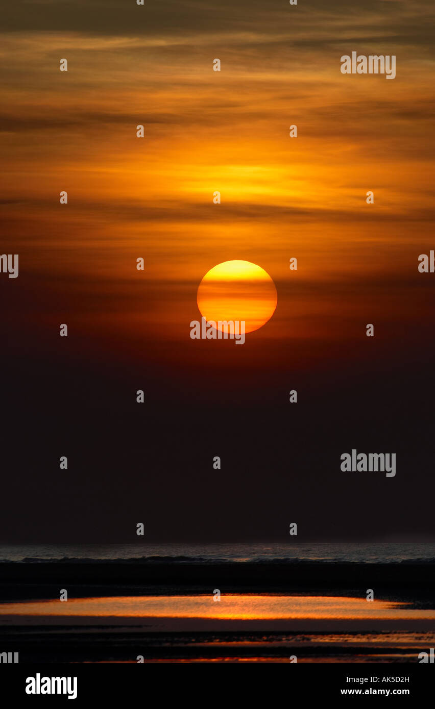 The sun about to disappear below the horizon with strong golden ...