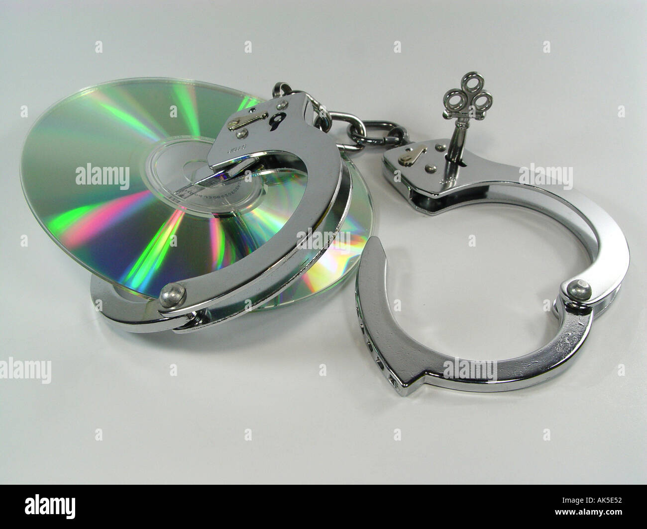 CD Rom with handcuffs as symbol for copy protection and or arrest after ...