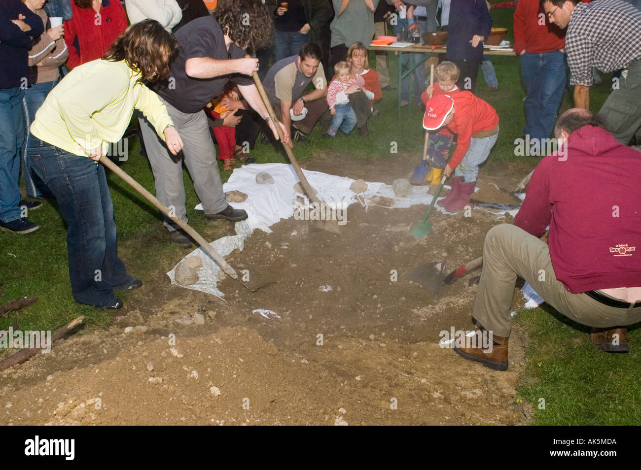 opening the pit oven at a curanto cooking in a pit oven vegetables and ...